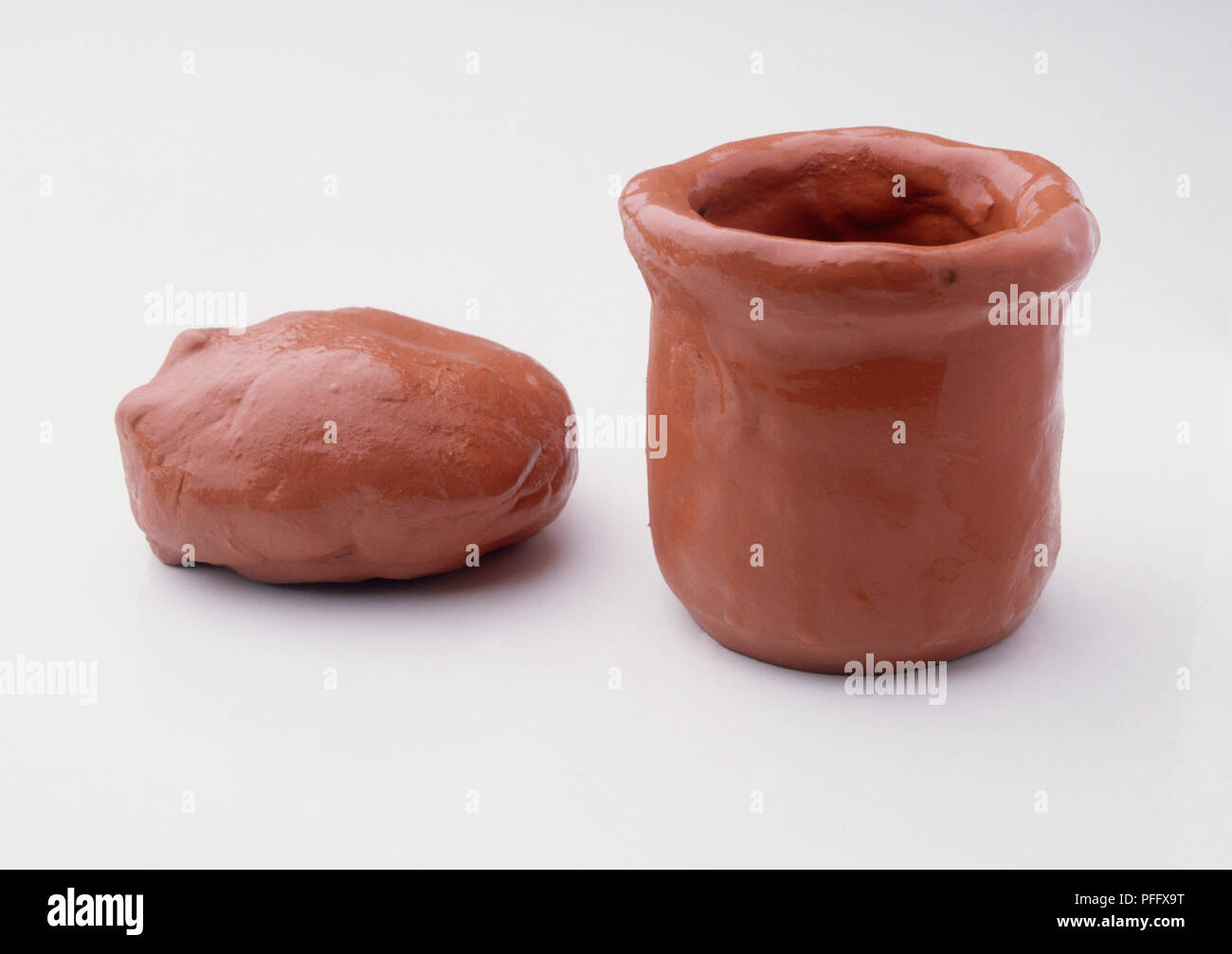 A piece of raw clay and a roughly shaped clay pot Stock Photo - Alamy