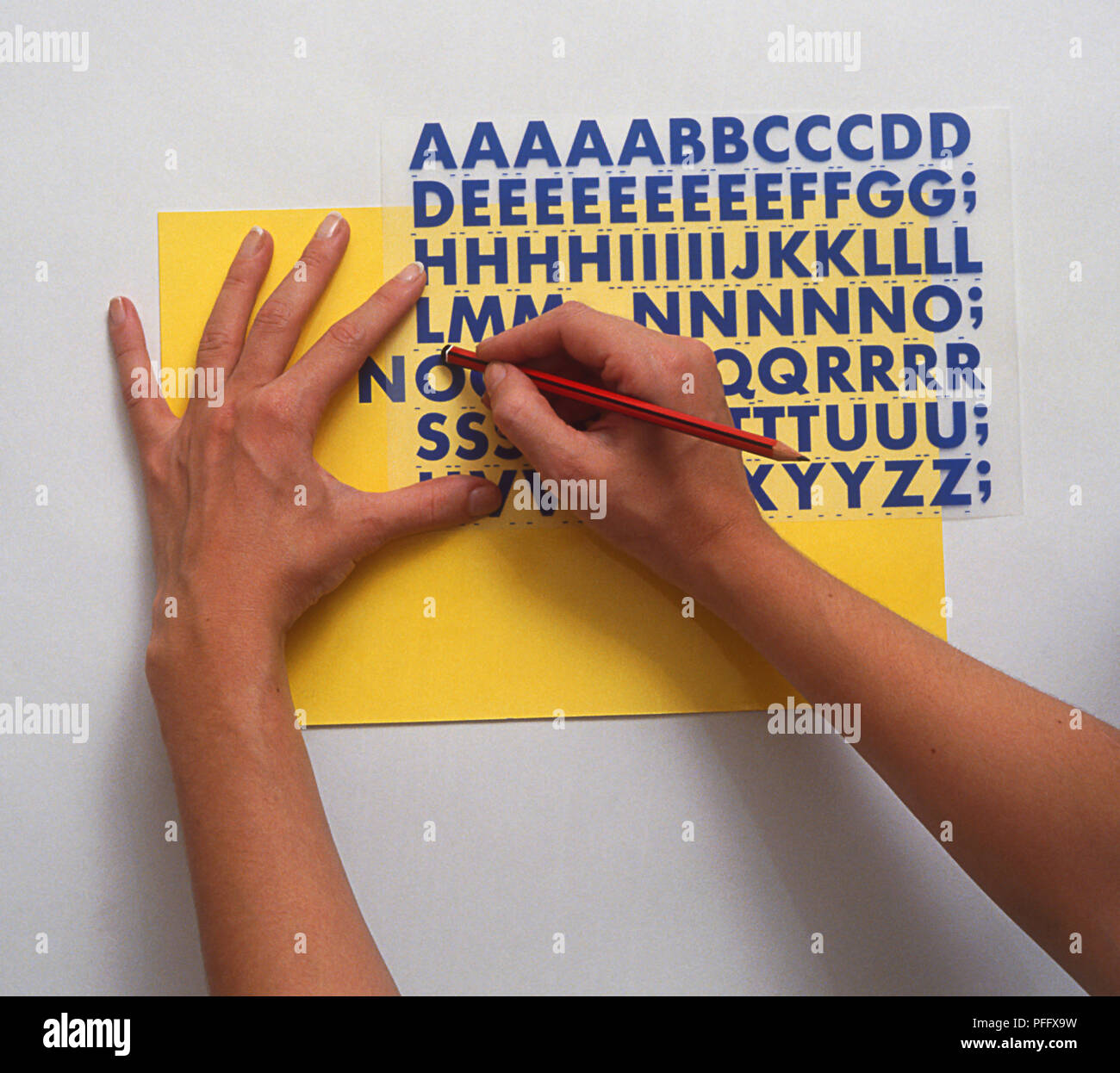 Woman's hands rubbing letters onto paper, close-up Stock Photo - Alamy