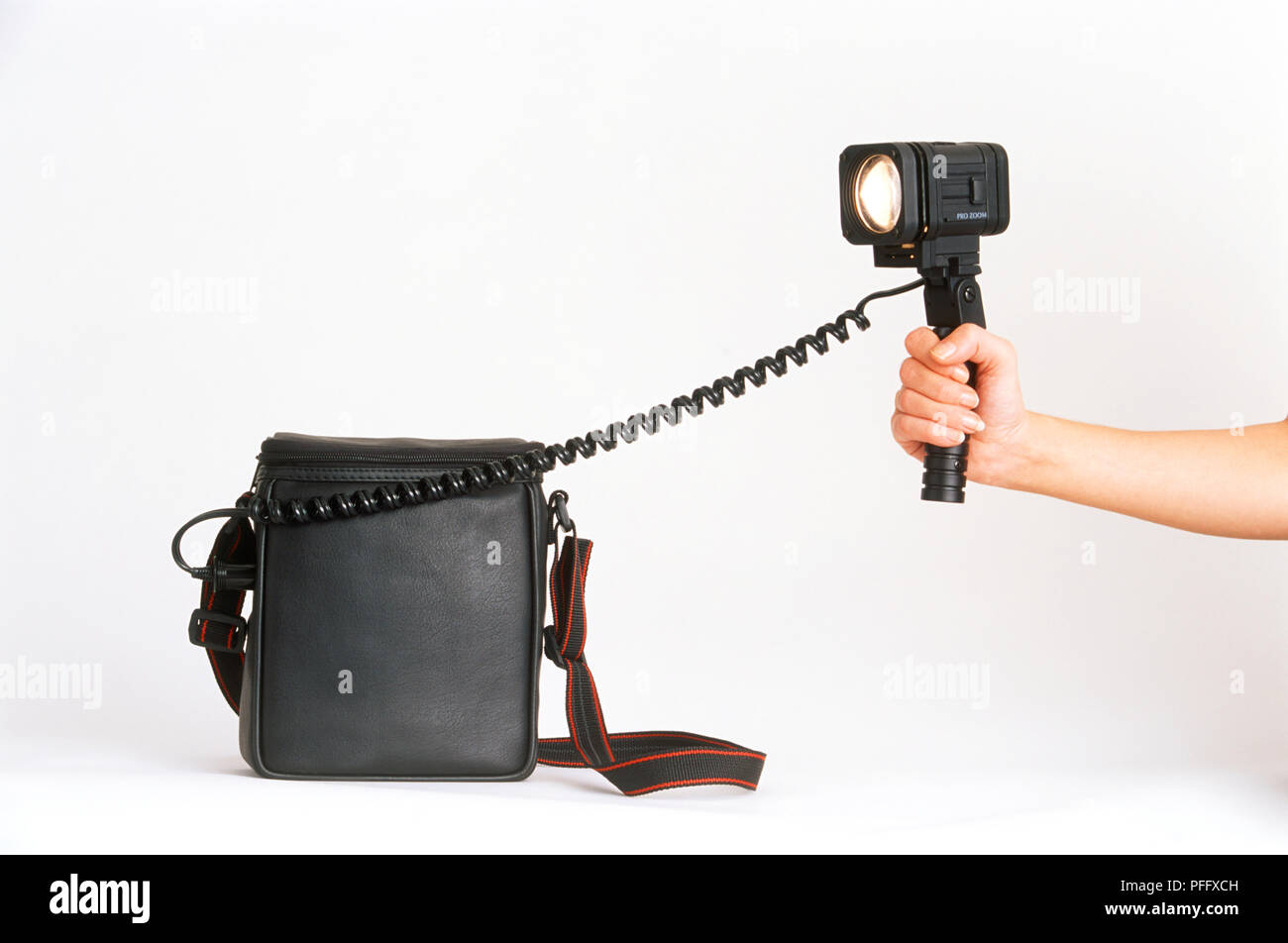Person holding a hand-held light with battery pack Stock Photo - Alamy