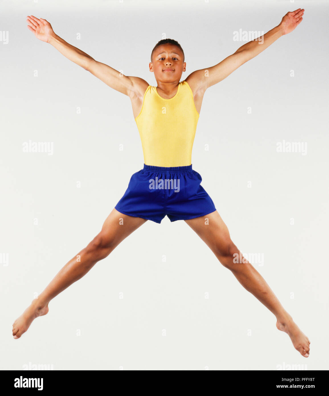 Boy doing a star jump Stock Photo - Alamy