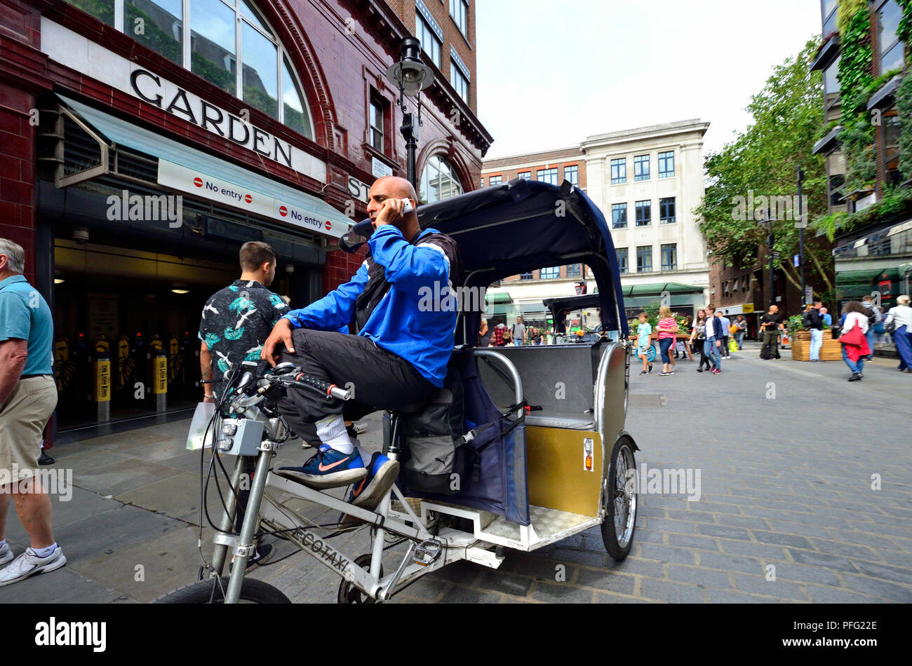 Rickshaw driver on his mobile phone by Covent Garden underground ...