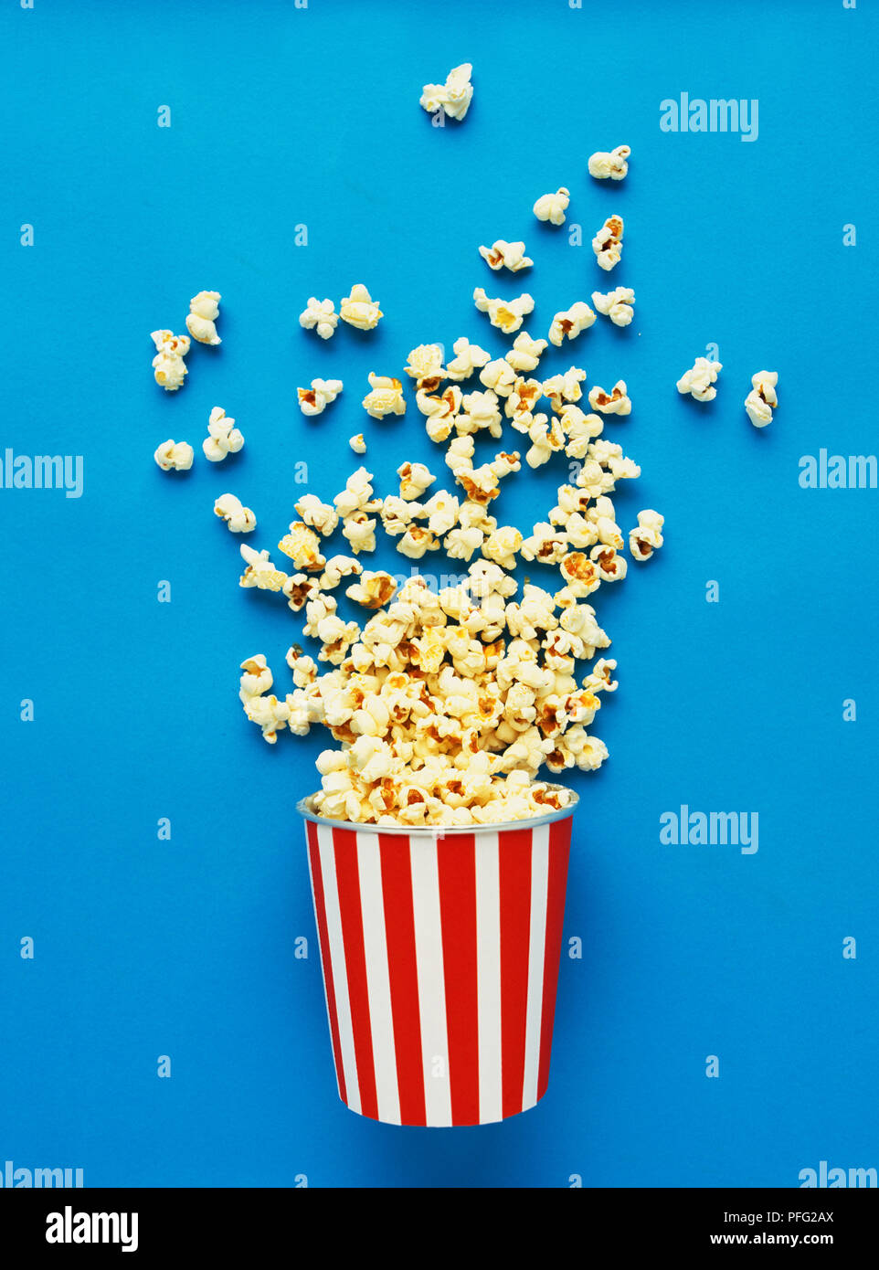 Popcorn falling out of a tub Stock Photo - Alamy