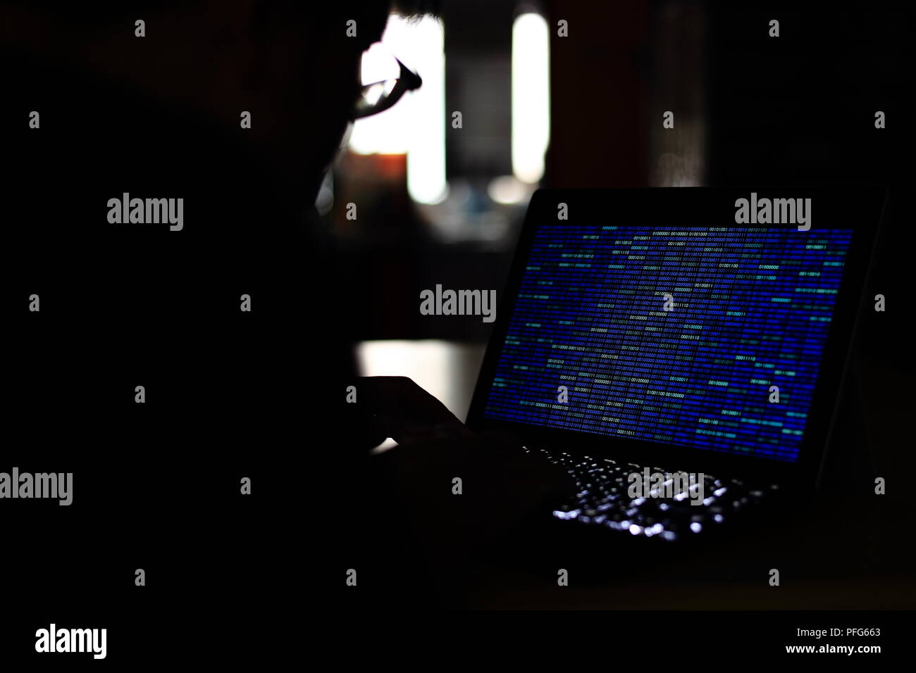 Computer Hacker silhouette typing on computer in a dark room. Working ...