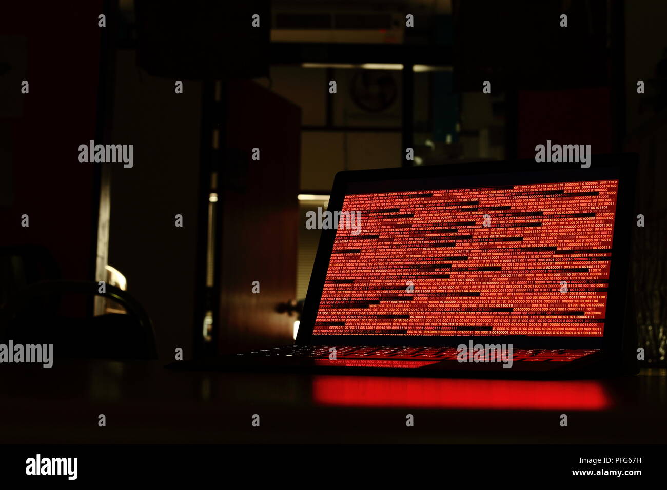 Computer crime. computer with red code in a dark room. Working on ...