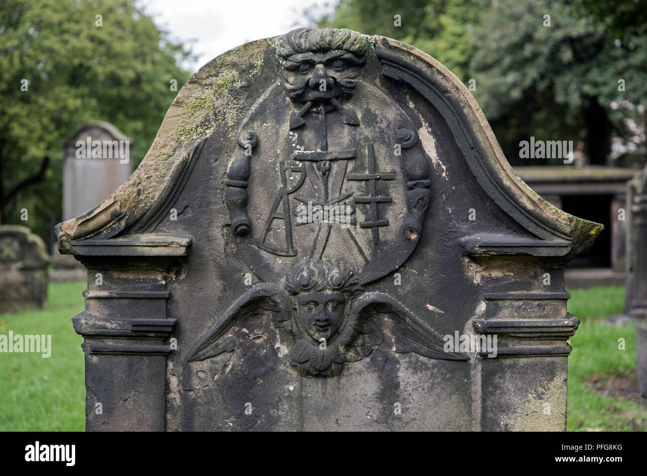 Carved heads and symbols on a headstone in North Leith Burial Ground ...
