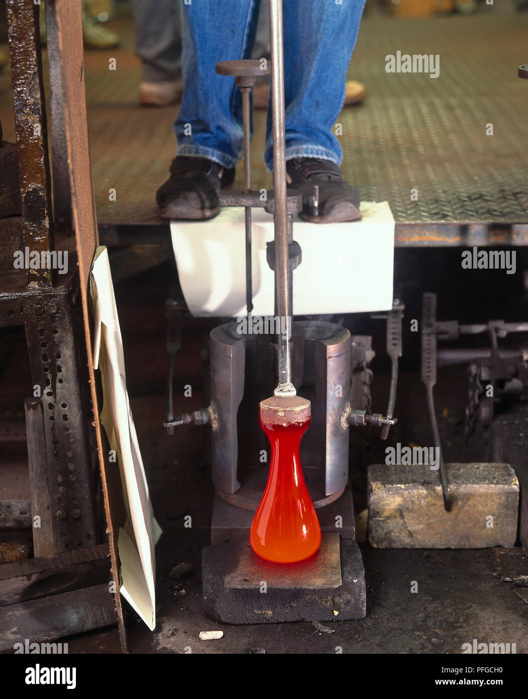 Step in the traditional making of a glass bottle, making the parison ...