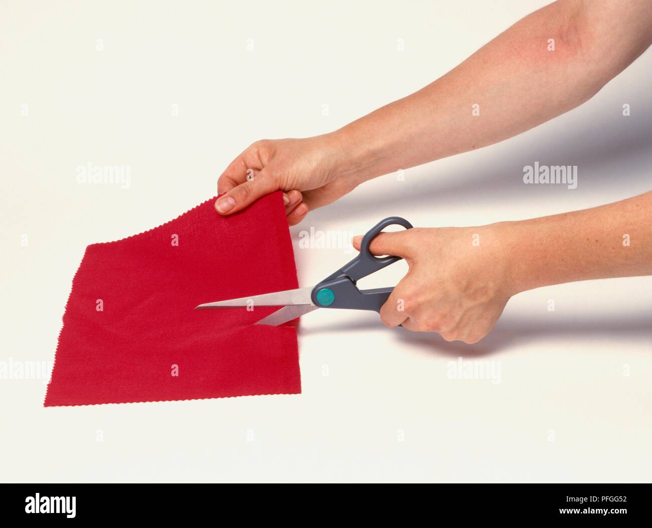 Piece of cloth being cut with scissors Stock Photo - Alamy