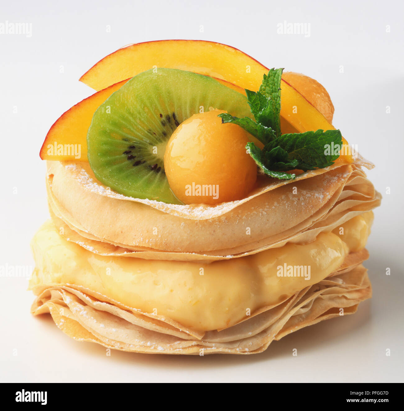 Mango millefeuille dessert, garnished with fresh mango, kiwi and mint ...