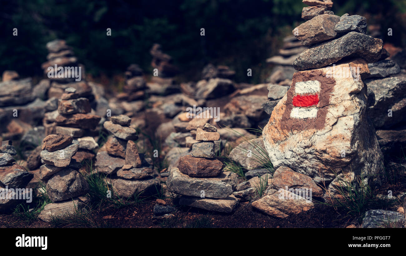Hiking trail sign mark painted on a rock in stack of zen stones. Path ...