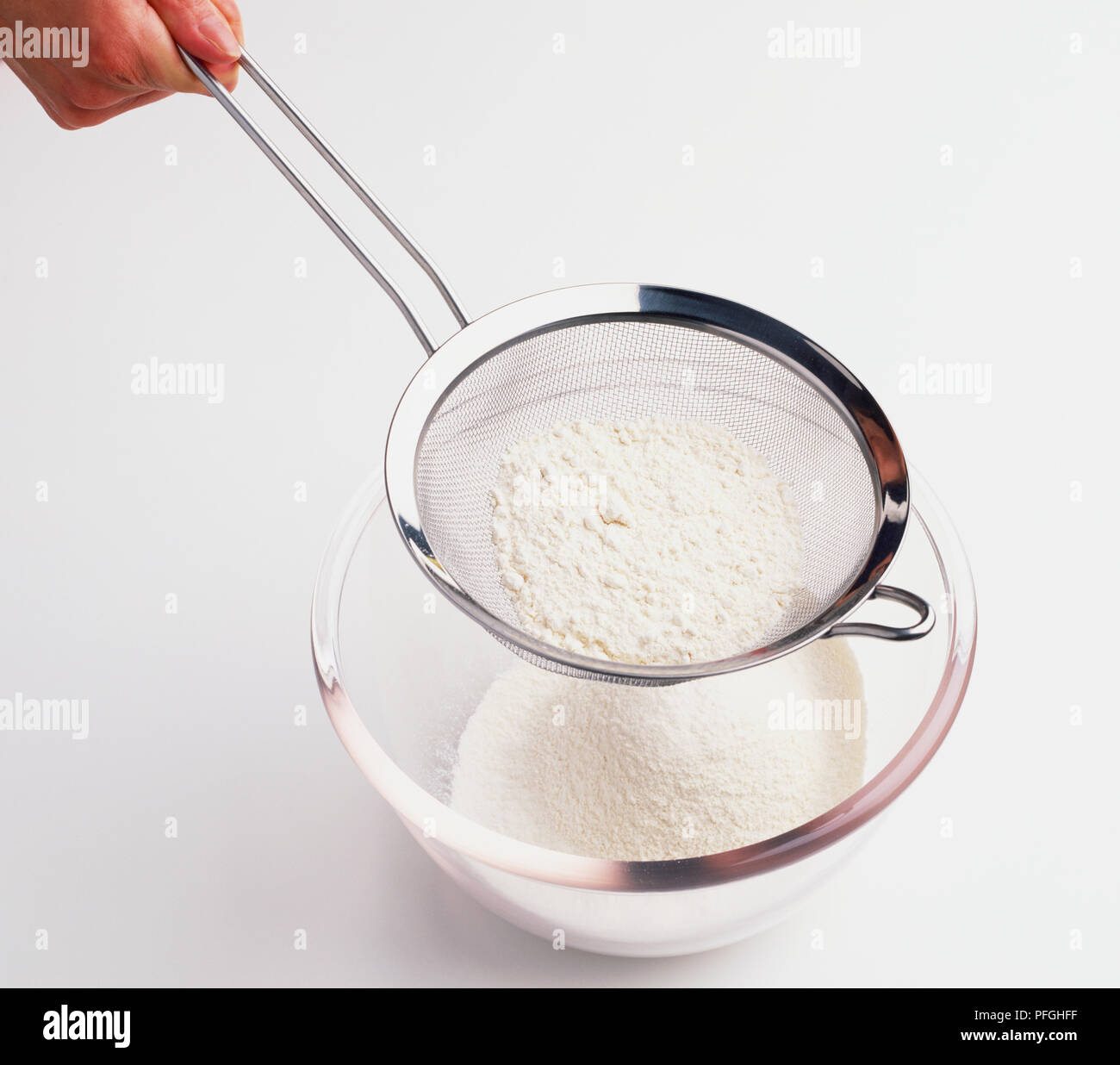 Sieving Flour with Salt into Glass Bowl Stock Photo - Alamy