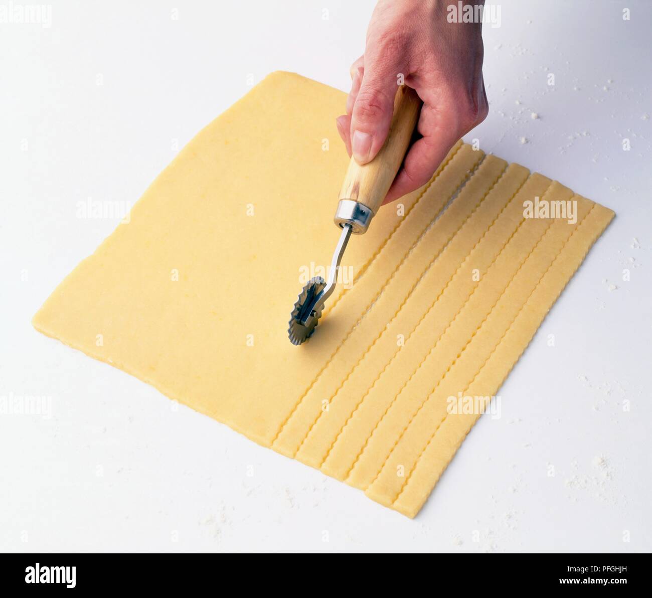 Cutting fresh pastry using pastry wheel Stock Photo - Alamy