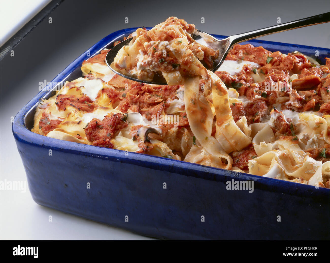 Spoon lifting tagliatelle out of dish Stock Photo - Alamy