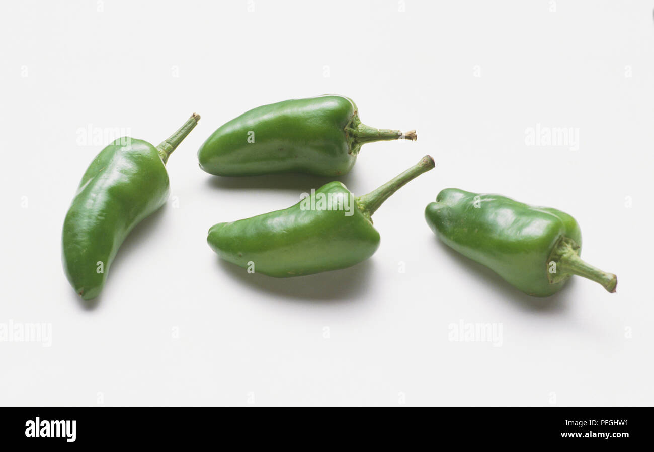 Four whole, green chili peppers Stock Photo - Alamy