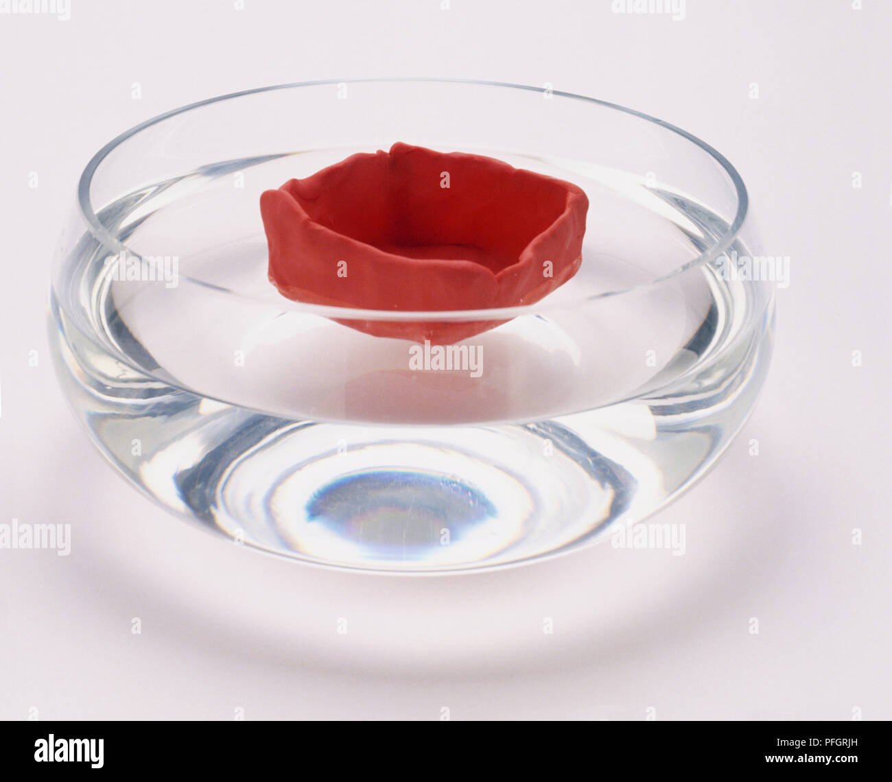 A hollowed out piece of plasticine shaped as a bowl floating in a bowl ...