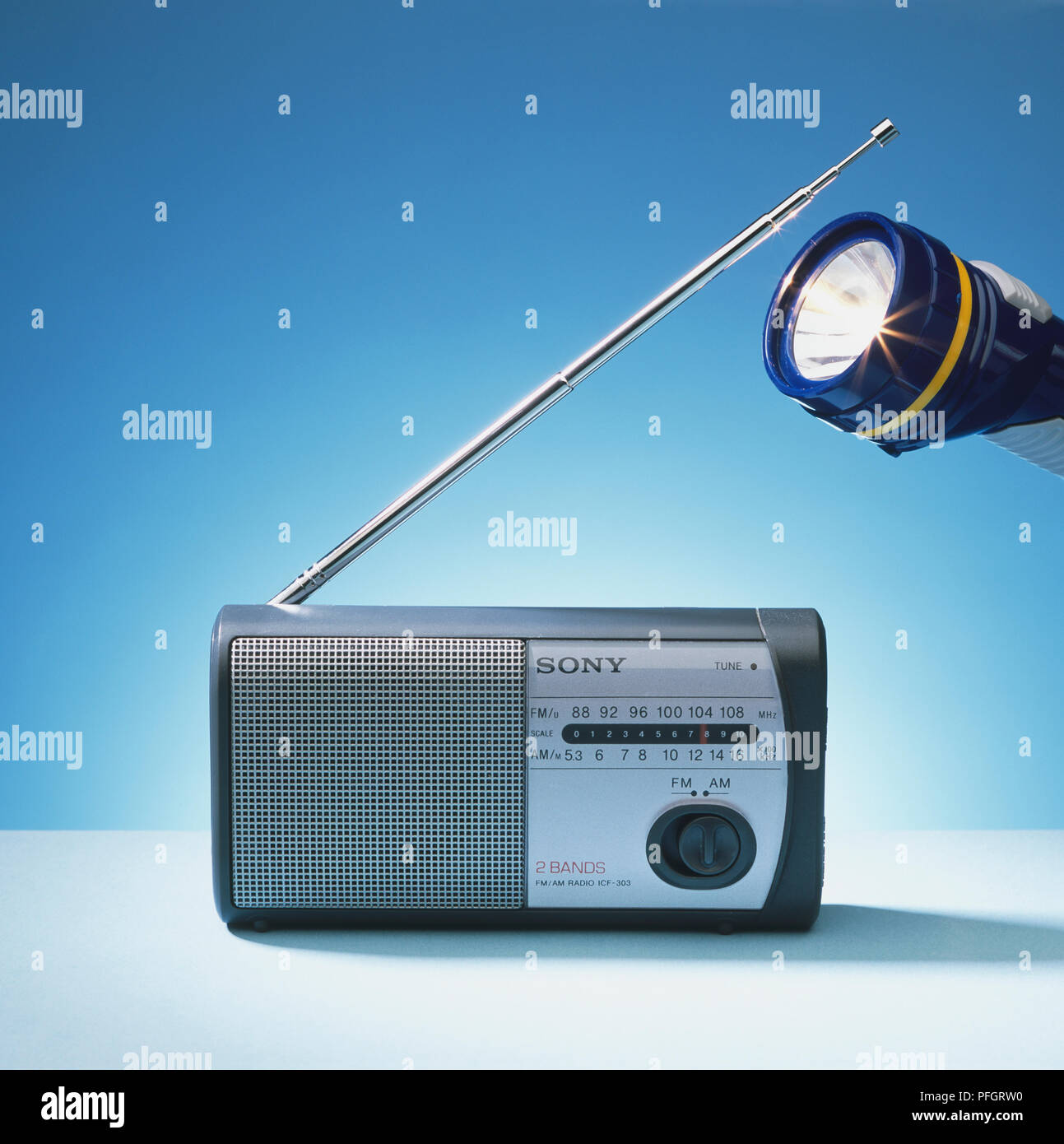 Transistor radio with aerial partially raised, lit electric torch Stock ...