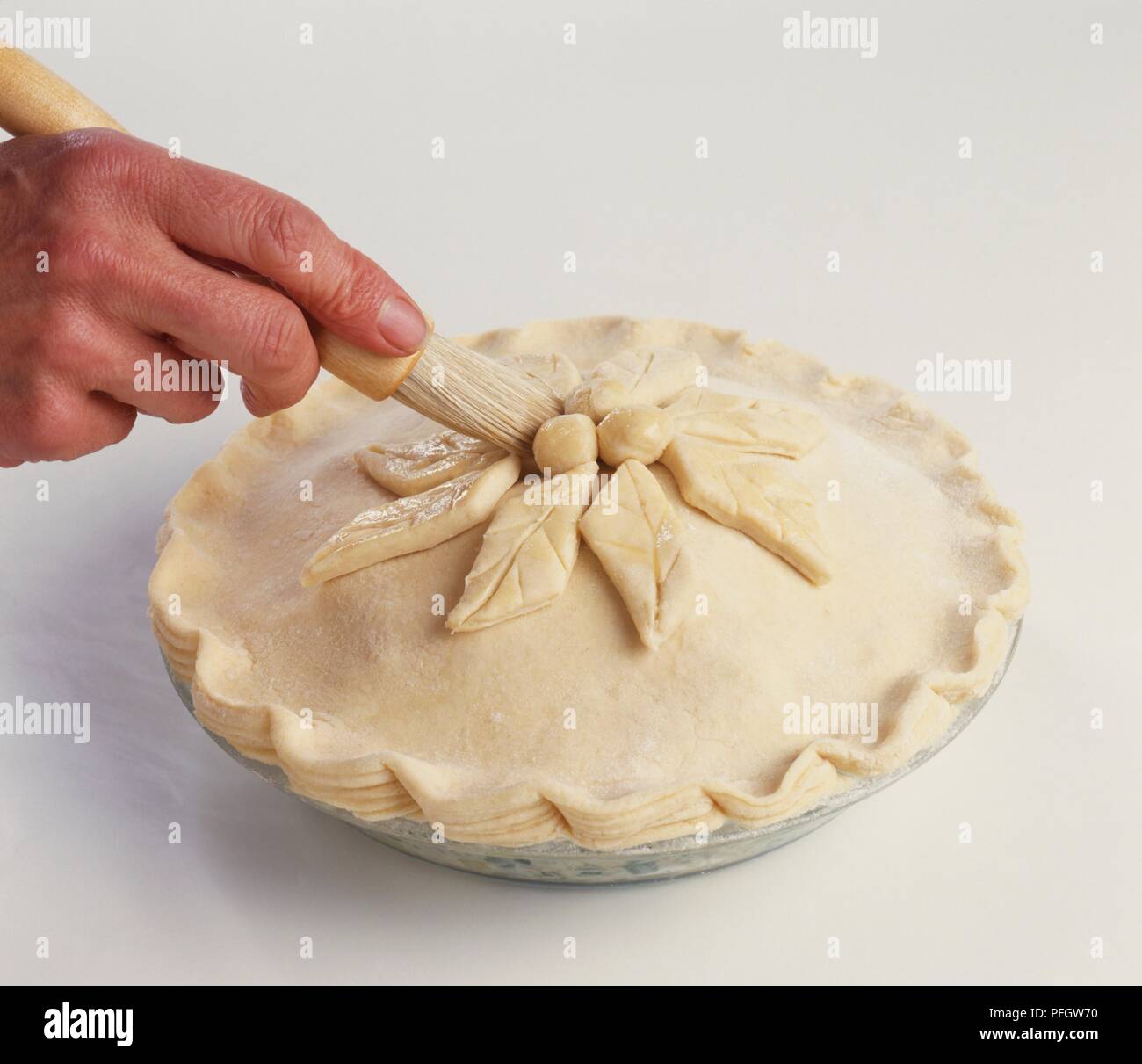 Brushing top of dessert pie with milk Stock Photo - Alamy