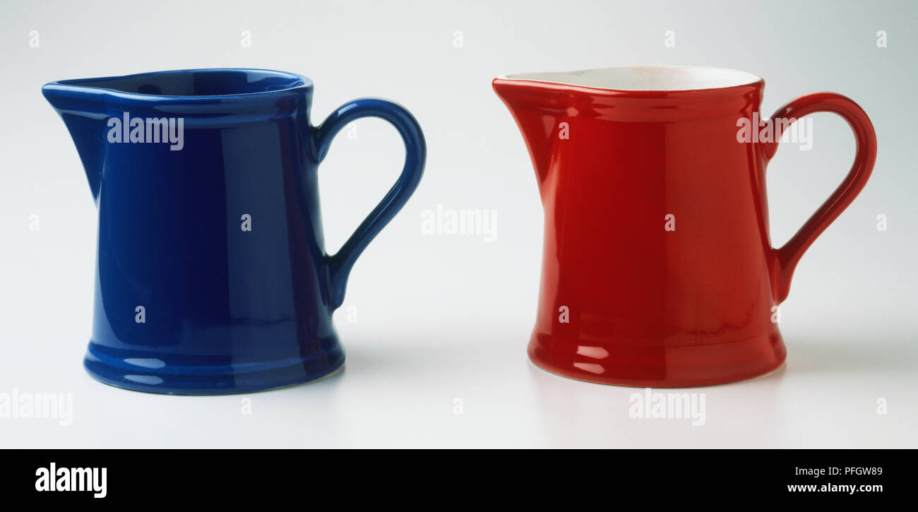 Two ceramic jugs, one red, one blue Stock Photo - Alamy