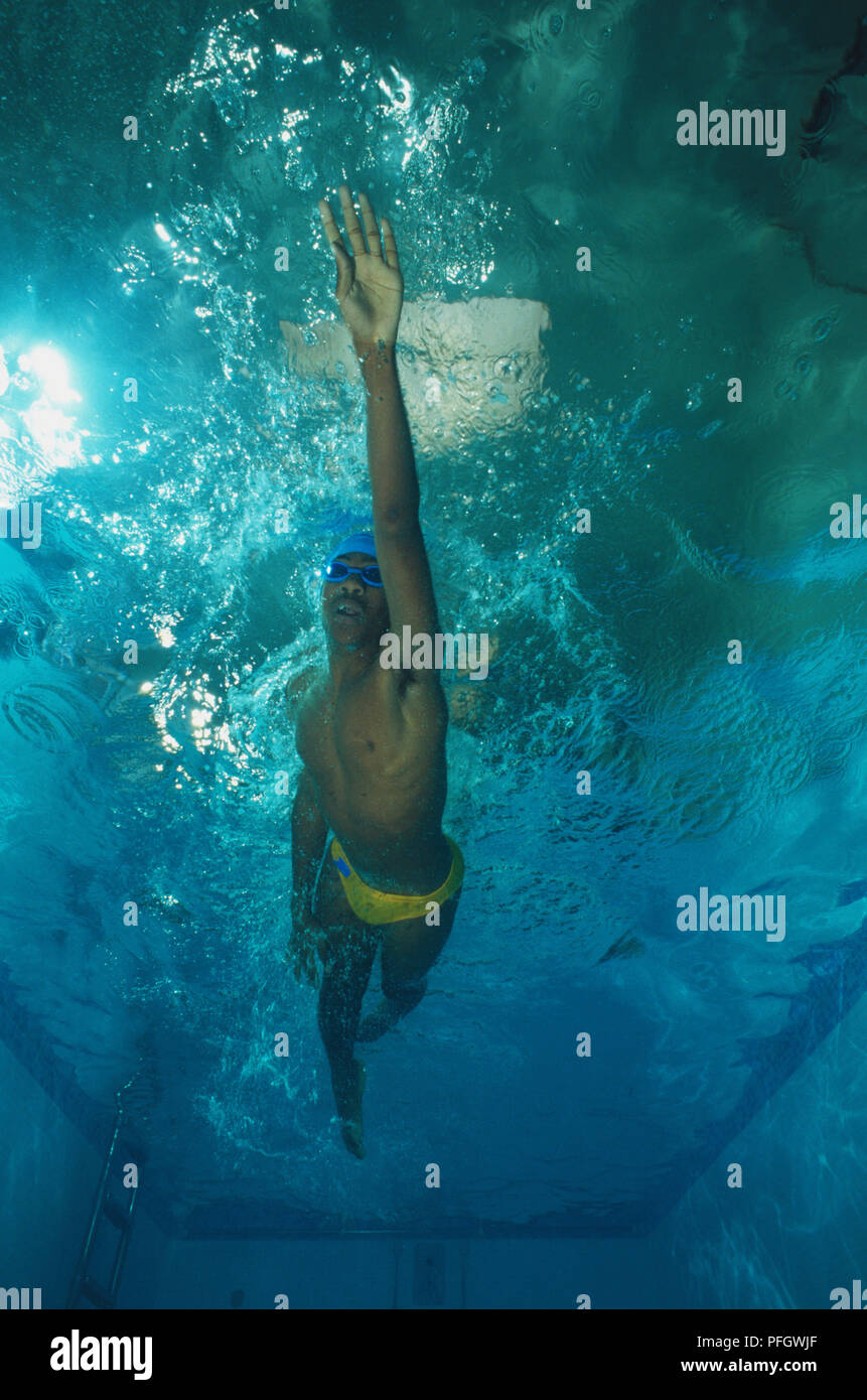 Man Wearing Yellow Swimming Trunks, Blue Cap And Goggles Doing Front ...
