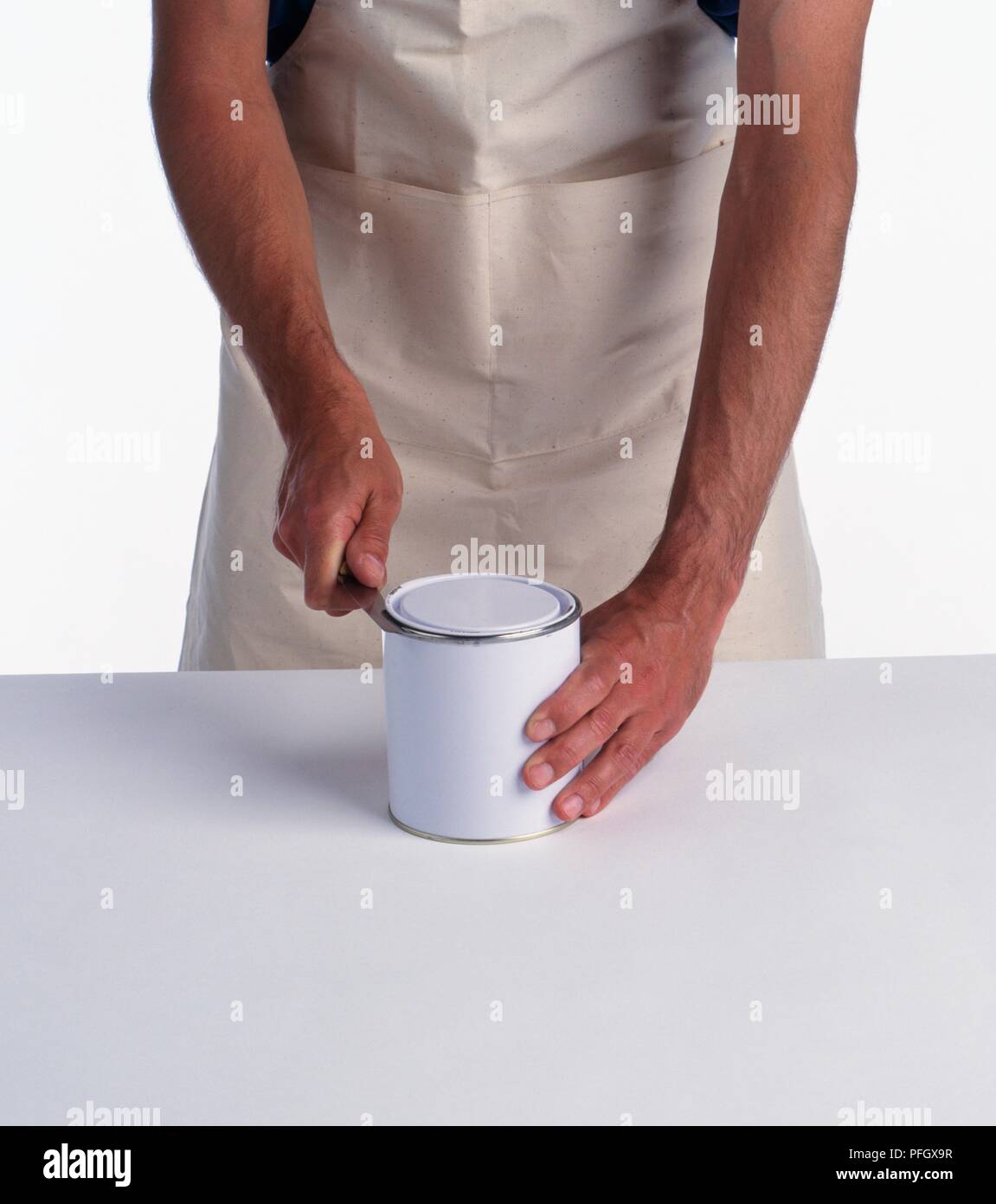 Using blade of small knife to remove lid from paint tin Stock Photo - Alamy