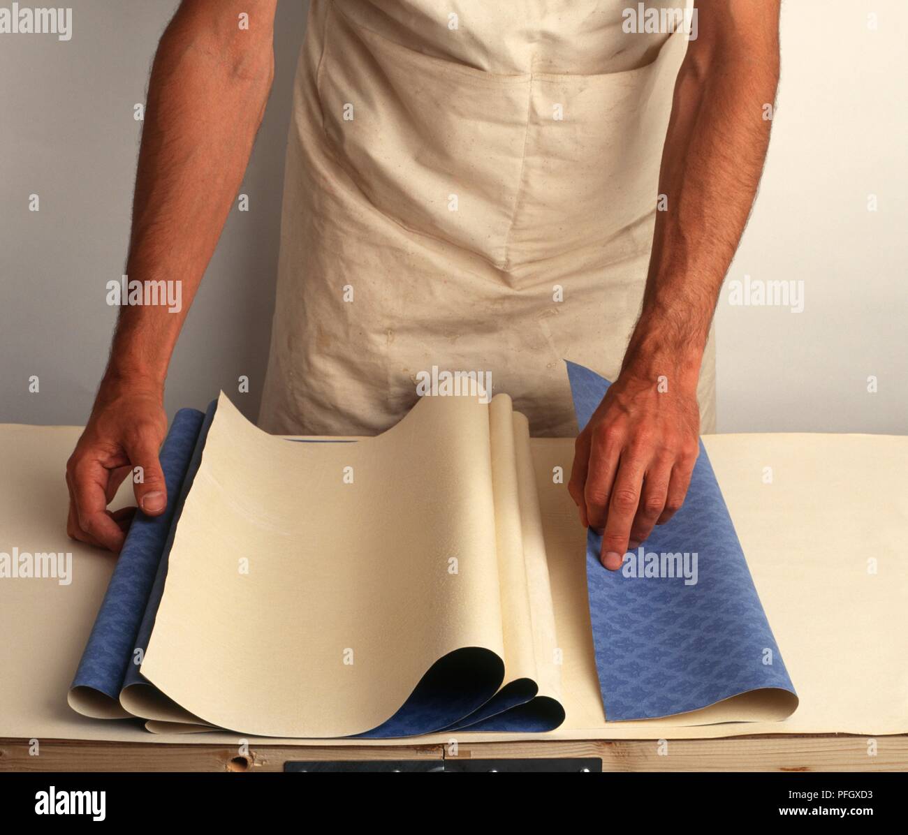 Folding up lengths of wallpaper, close-up Stock Photo - Alamy