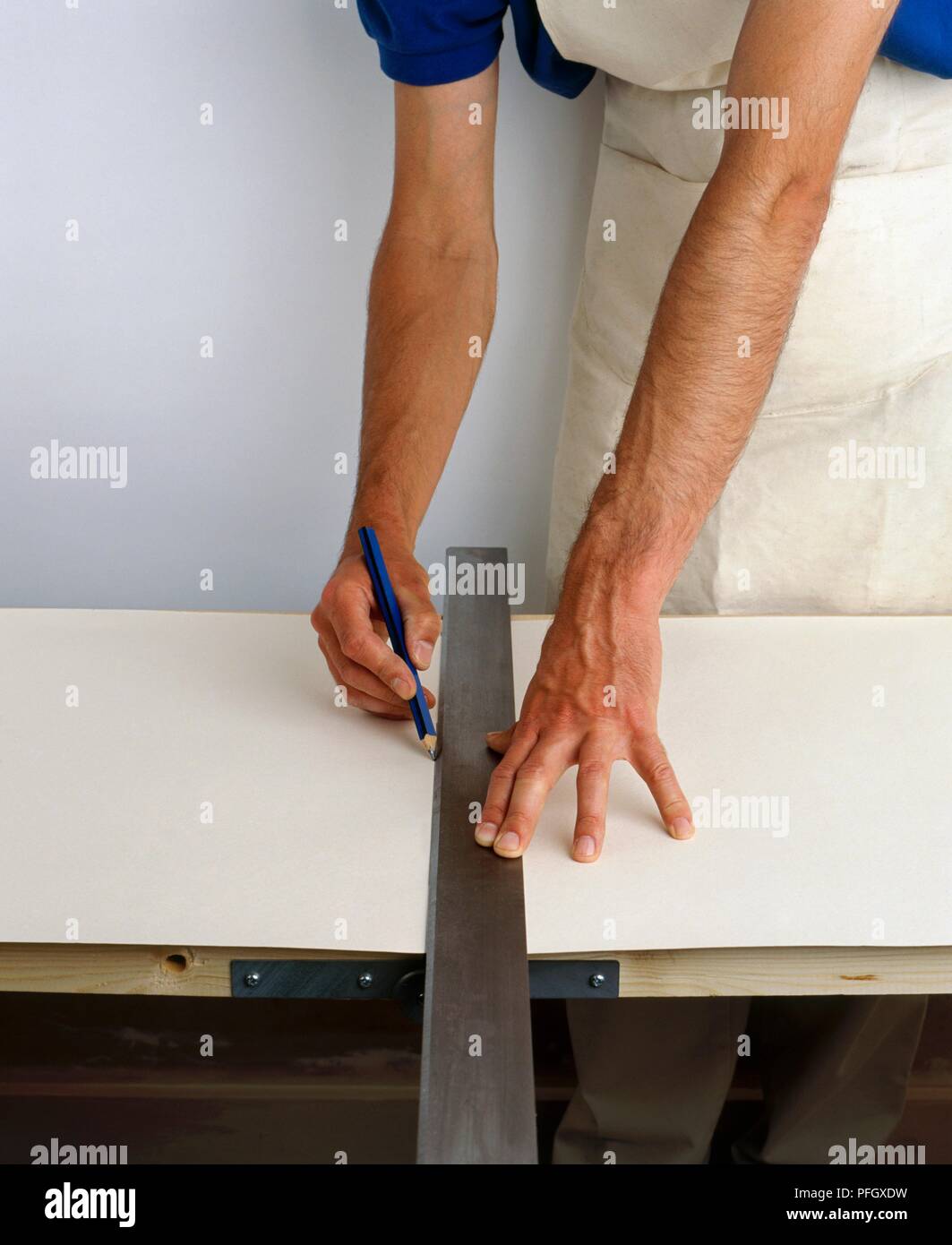 Using ruler to draw a straight cutting line across width of lining ...