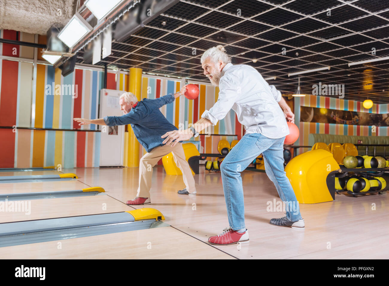 Delighted positive aged men playing bowling together Stock Photo - Alamy
