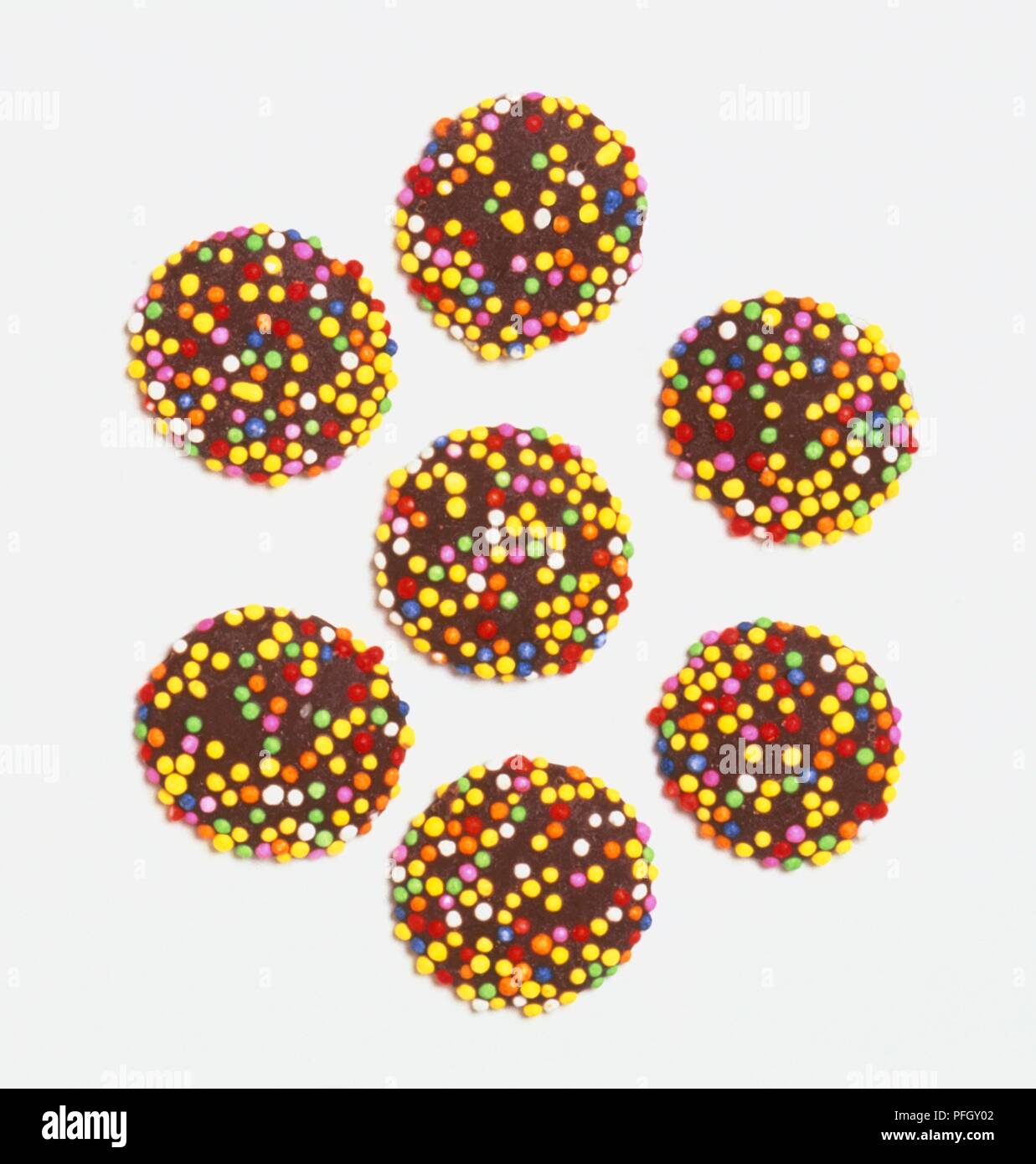 Seven chocolate-coated sweets, topped in coloured hundreds and ...