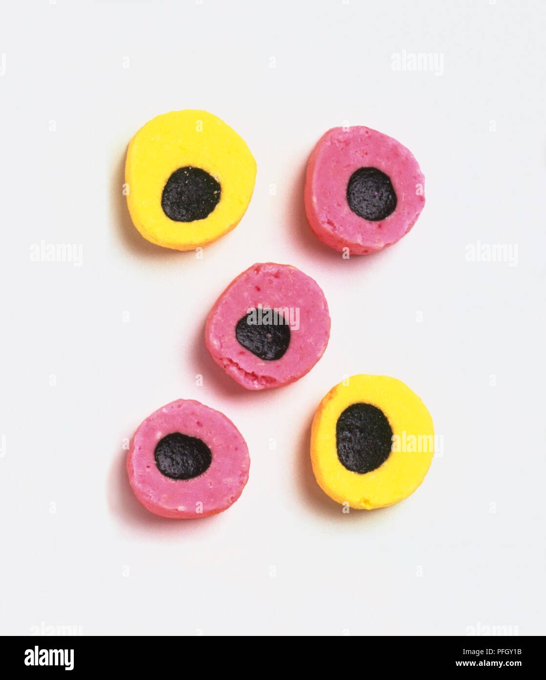 Five pink and yellow sweets with liqourice in their centres Stock Photo ...