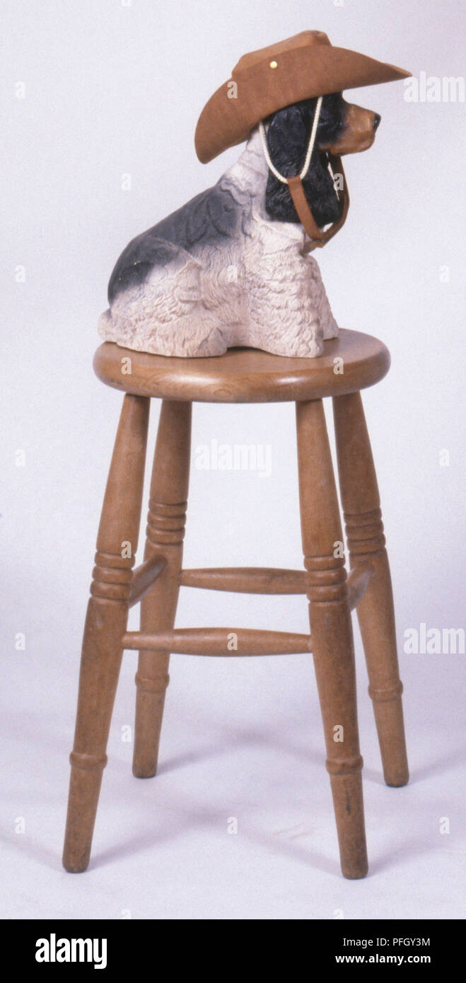 Plastic toy poodle with cowboy hat on, on a stool, side view Stock ...