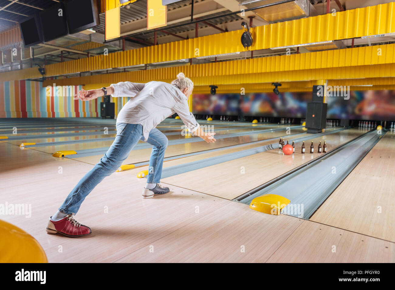Joyful nice man throwing the bowling ball Stock Photo - Alamy