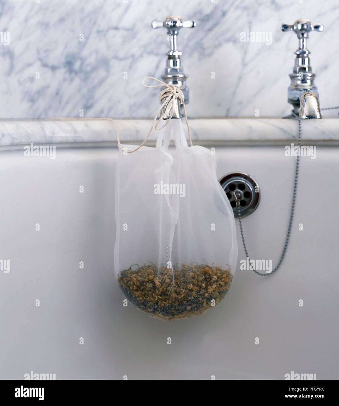 Herbal bath bag tied to bath tap with string Stock Photo - Alamy