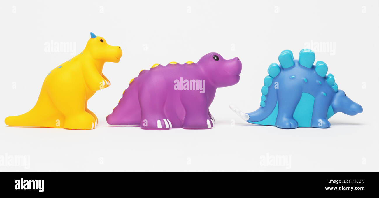 Three plastic dinosaurs in a row, side view Stock Photo - Alamy