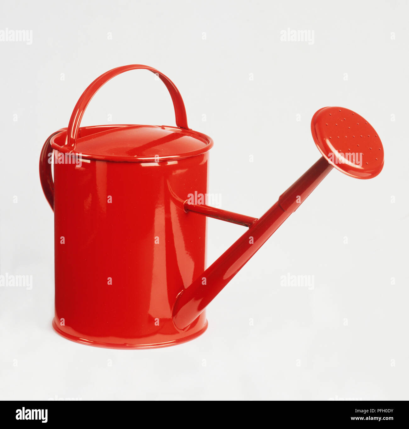 Shiny red watering can, side view Stock Photo - Alamy
