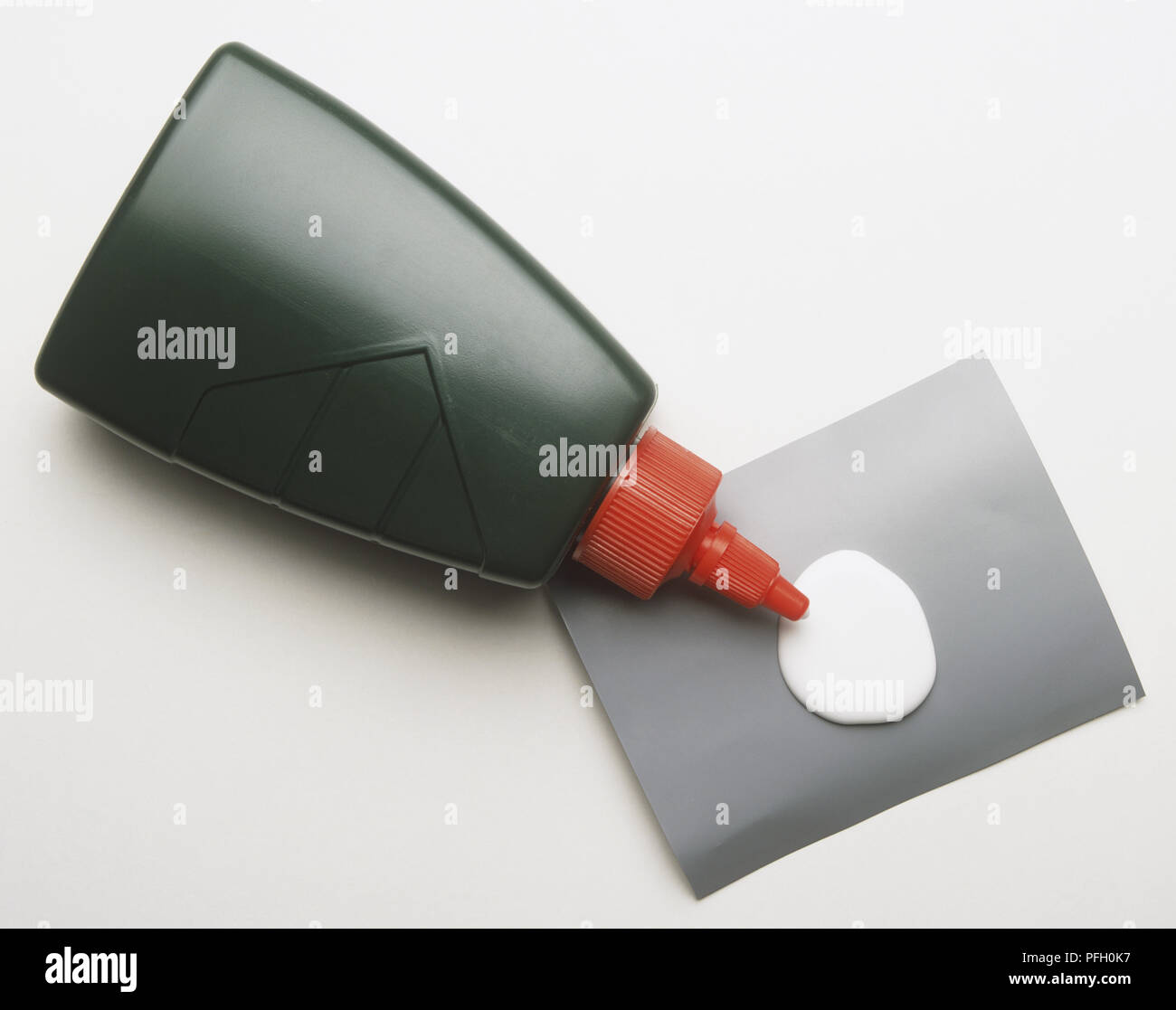 White paint spilling from red spout of plastic bottle Stock Photo - Alamy