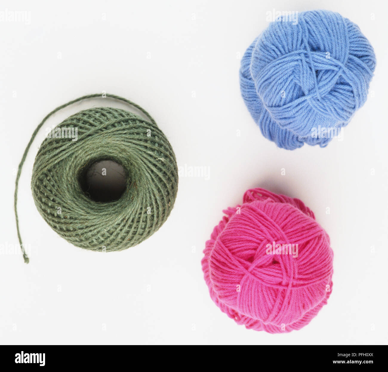Ball of pink wool and ball of blue wool, roll of green string, view ...