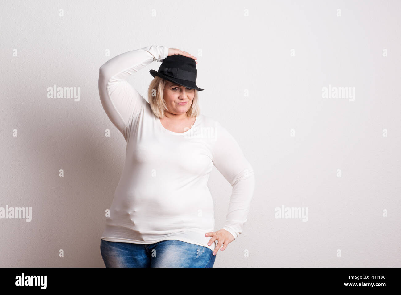 Portrait of an attractive blond overweight woman in studio on a white ...