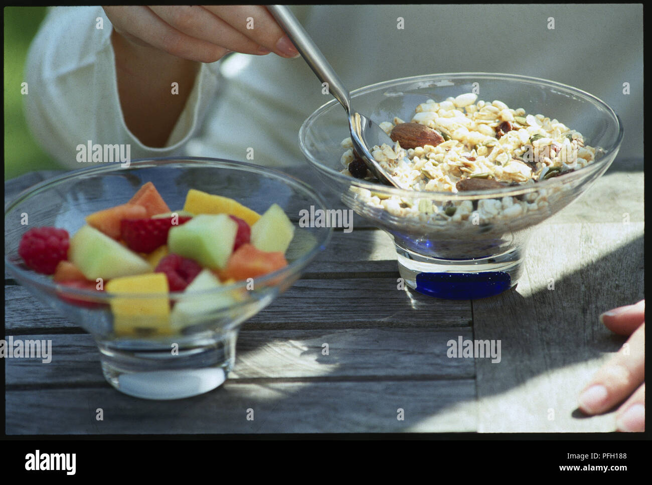 Woman eating form a bowl of cereal, bowl of chopped fruit Stock Photo ...