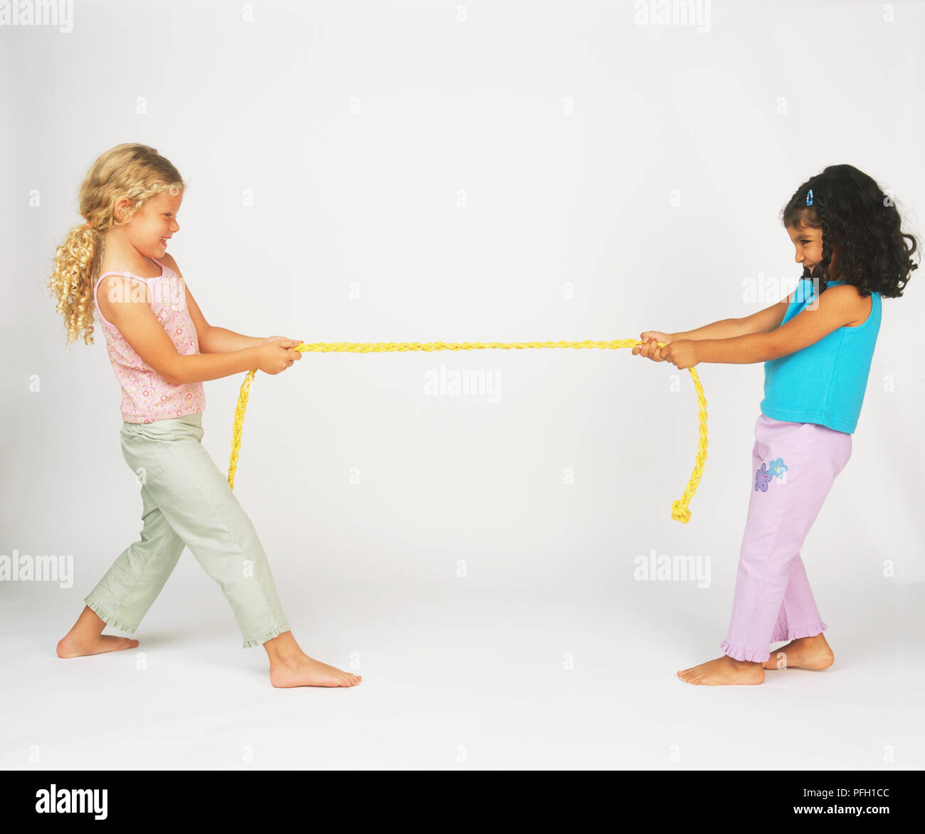 Two girls pulling on either end of rope Stock Photo - Alamy