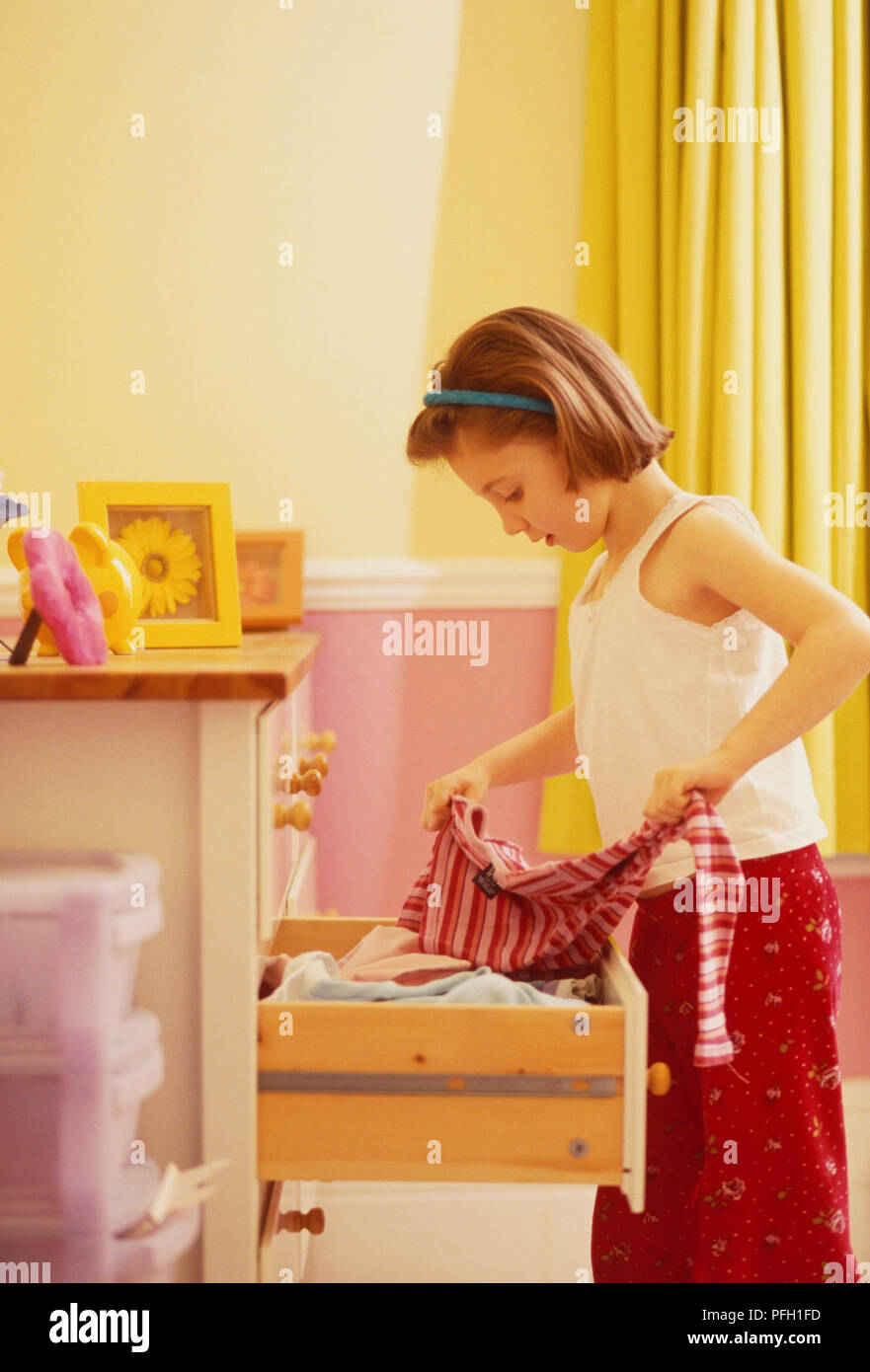 Young girl going through clothes in a drawer Stock Photo - Alamy