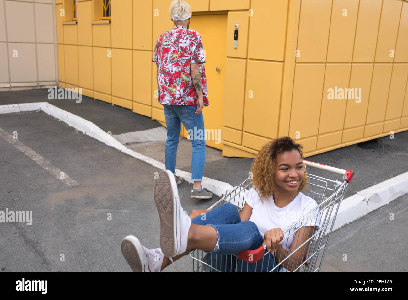 Friends have fun with shopping trolley Stock Photo - Alamy