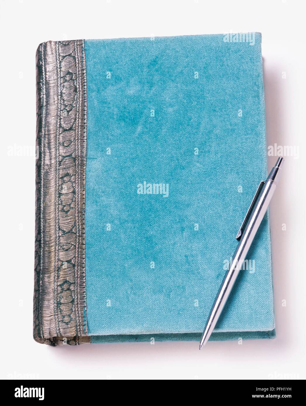 Turquoise coloured book with decorative spine and silver pen Stock ...