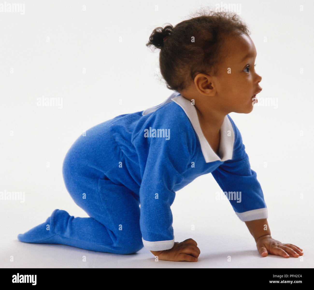 Baby wearing blue jumpsuit, crawling, side view Stock Photo - Alamy