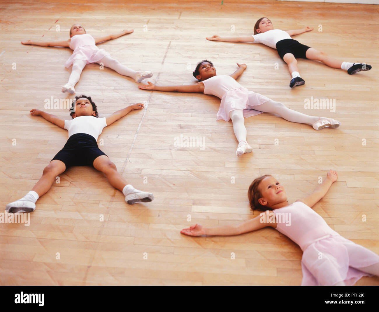 Ballet dancers lying on studio floor each making a star shape Stock ...