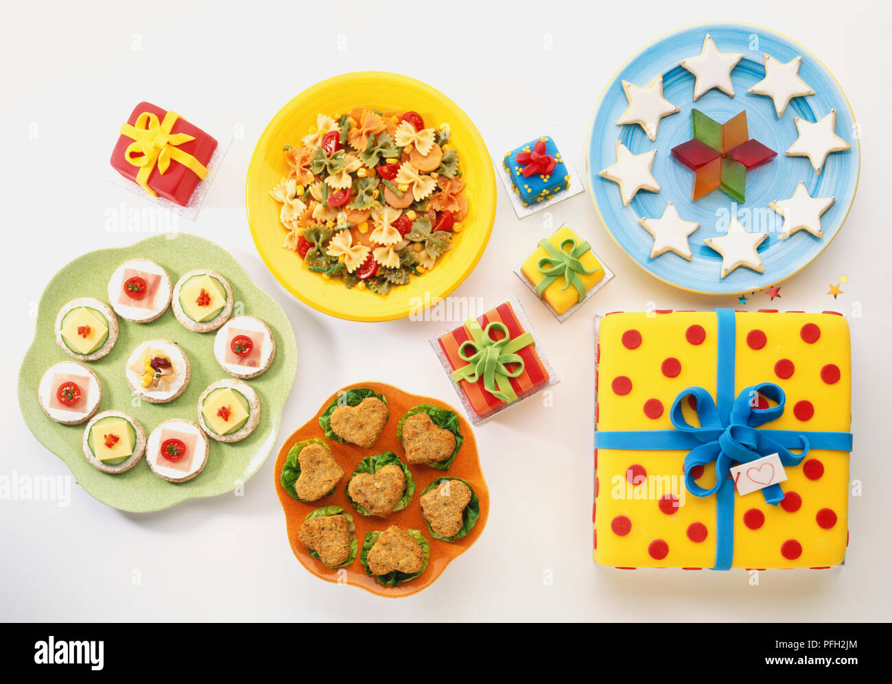 Above view of colourful children's food, on bright plates, pasta, cake ...