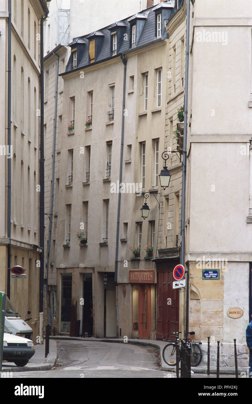 France, Paris, Marais, narrow alleyway lined with tall buildings ...