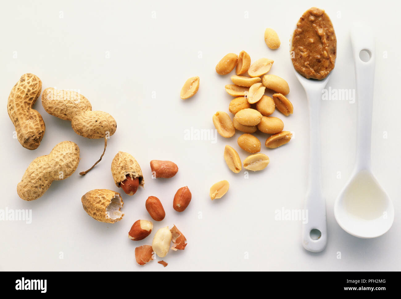 Above view of scattered peanuts, three shelled, one cracked, with skins ...