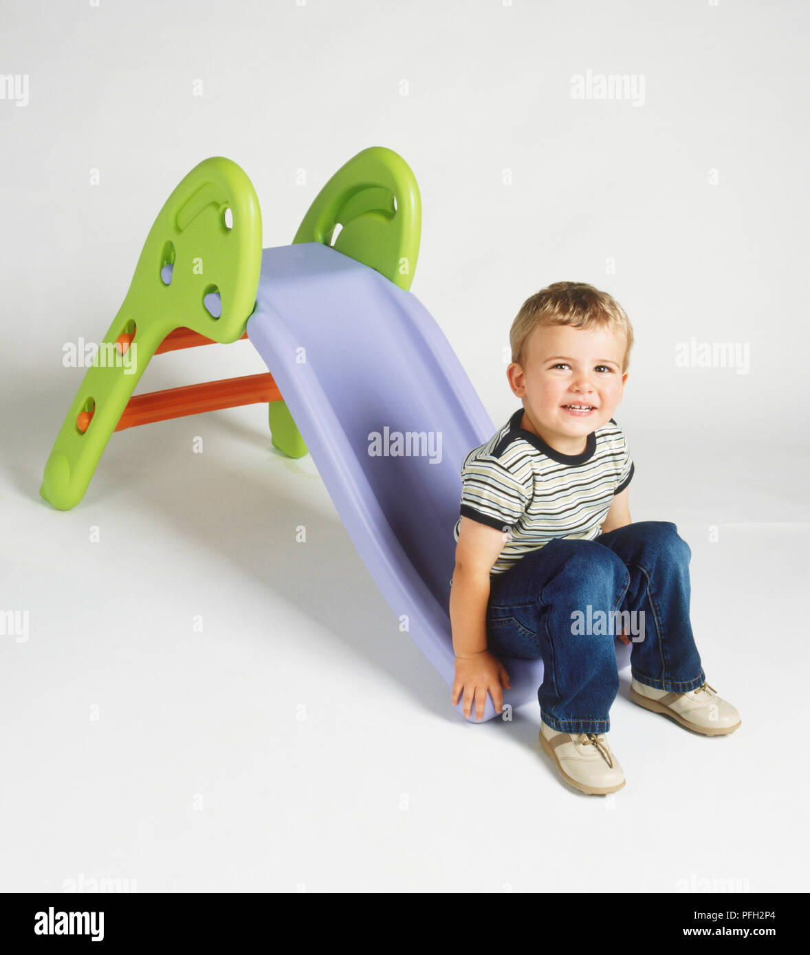 Boy at bottom of slide, smiling Stock Photo - Alamy
