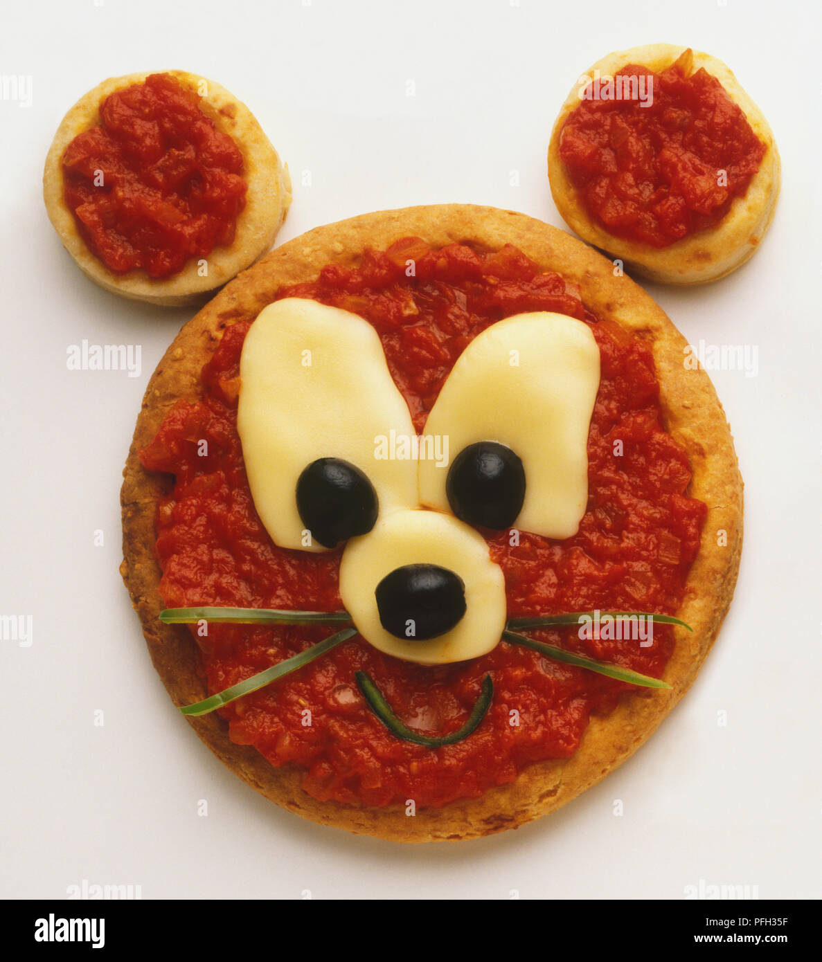Pizza designed in the shape of a smiling mouse face Stock Photo - Alamy