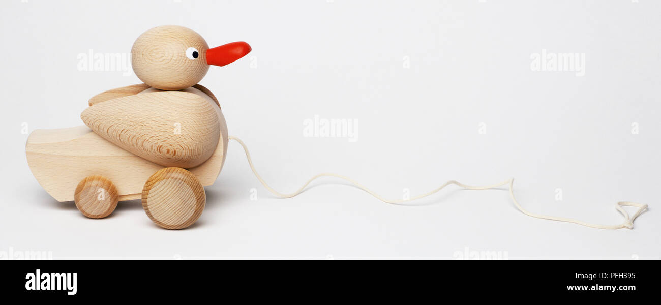 Wooden toy duck on wheels attached to towing string, side view Stock ...