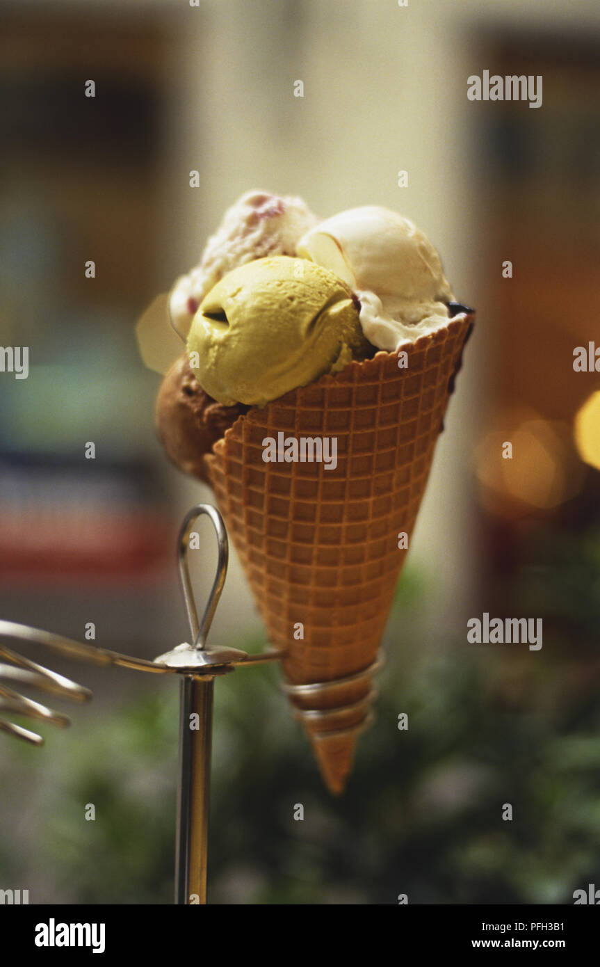 Multi-flavoured ice cream in cone on metal cone holder, close up Stock ...